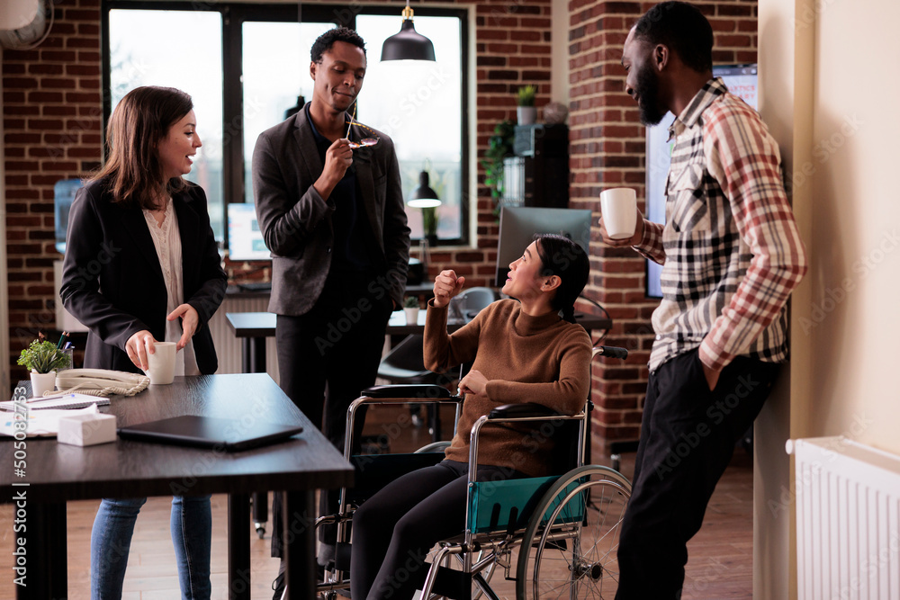 Multiethnic group of colleagues laughing in business office with ...