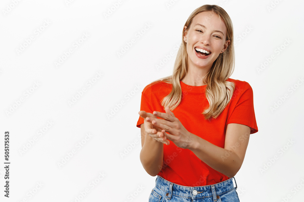 Beautiful modern girl, 25 years old, clapping hands and smiling pleased ...