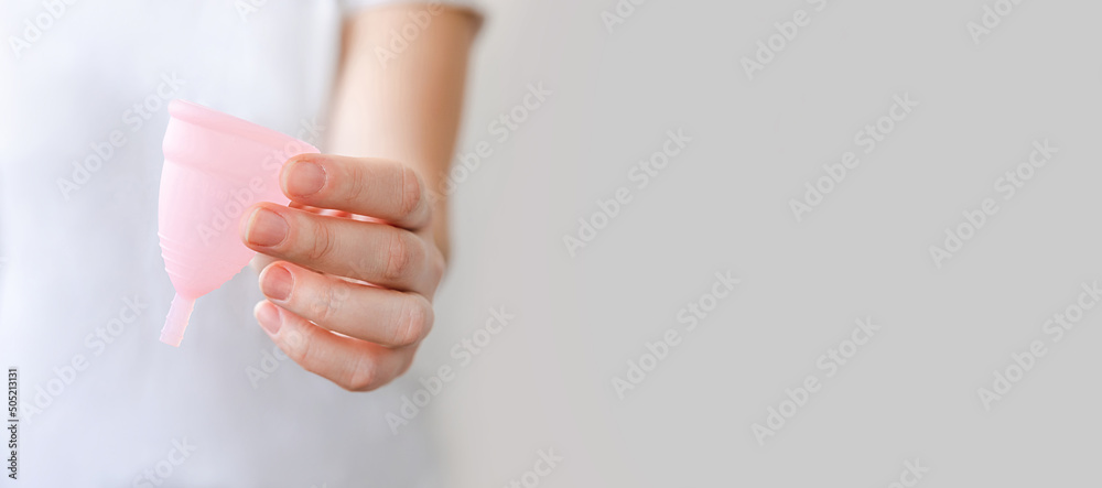 Woman hand holding pink menstrual cup isolated on white background ...
