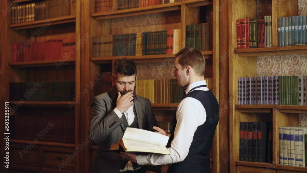 Business employees chatting in library. Concentrated professor and ...