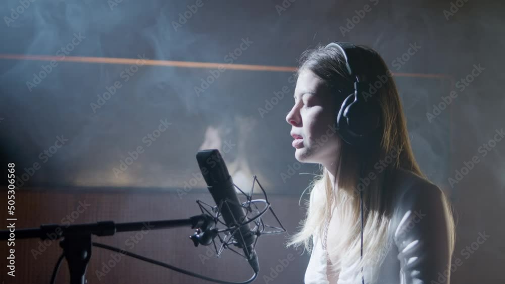 Beautiful female singer working in music studio while recording new ...