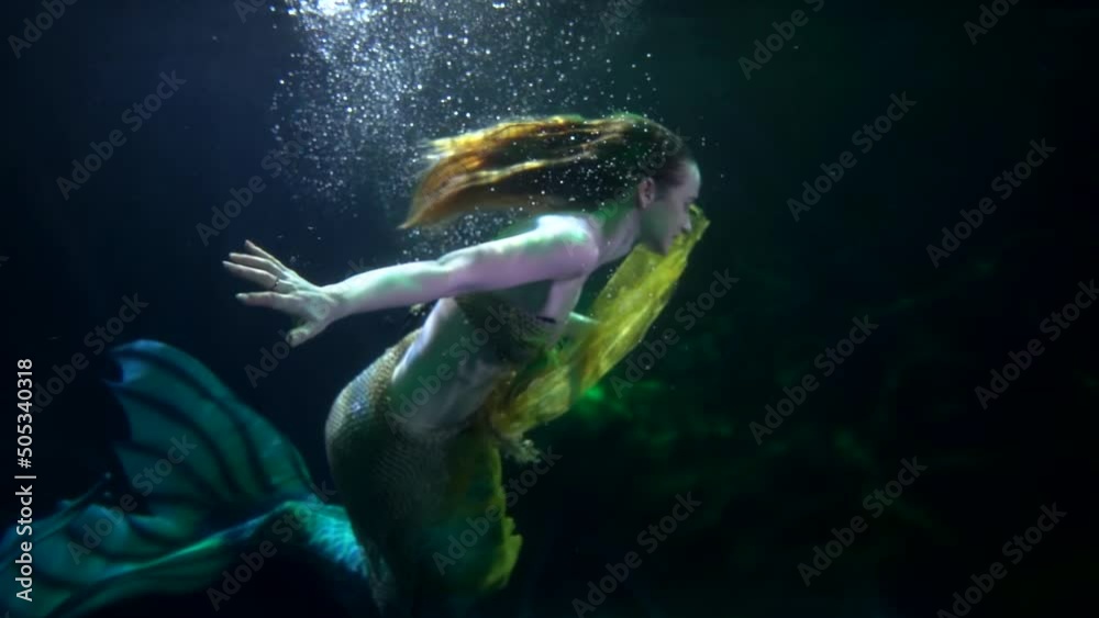mythical underwater creature is swimming in dark deepness of magic sea ...