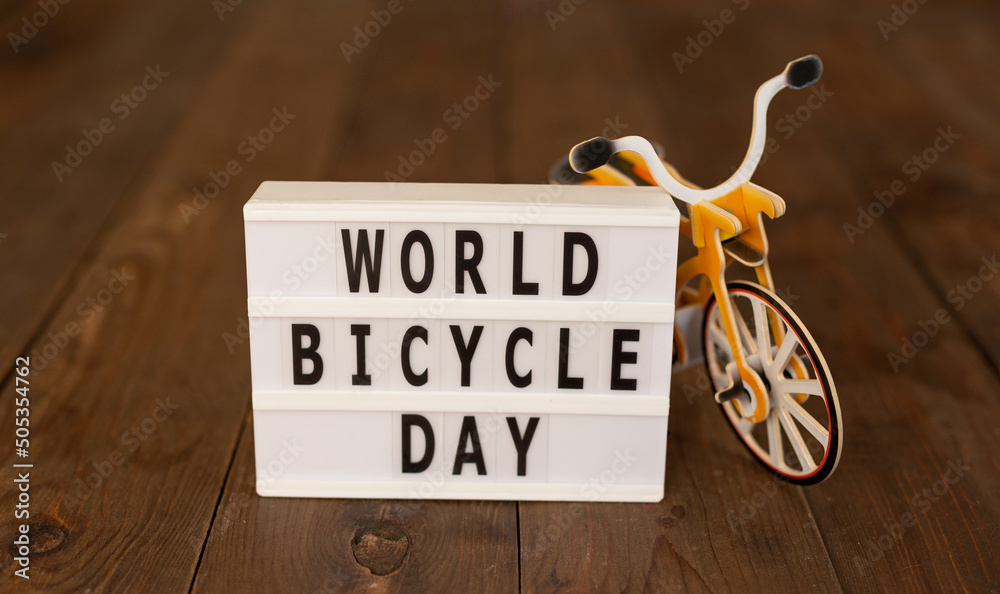 Toy bicycle and lightbox with text World bicycle day, environment ...