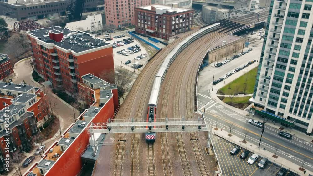 Aerial top view of a passenger train traveling in the city of Chicago ...
