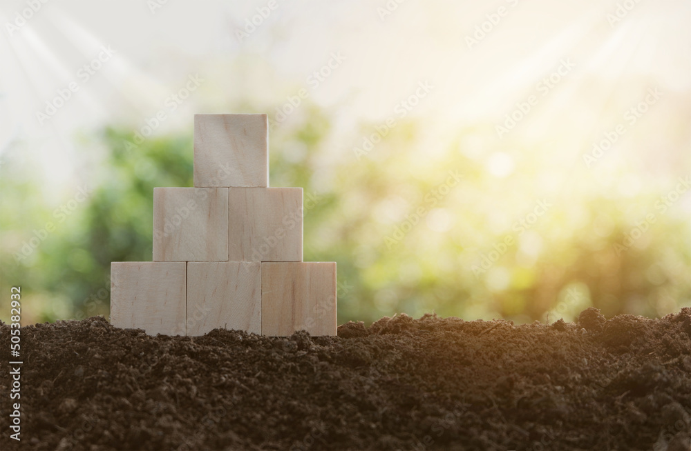 Six wooden blocks are placed on the groundwith green bokeh background ...