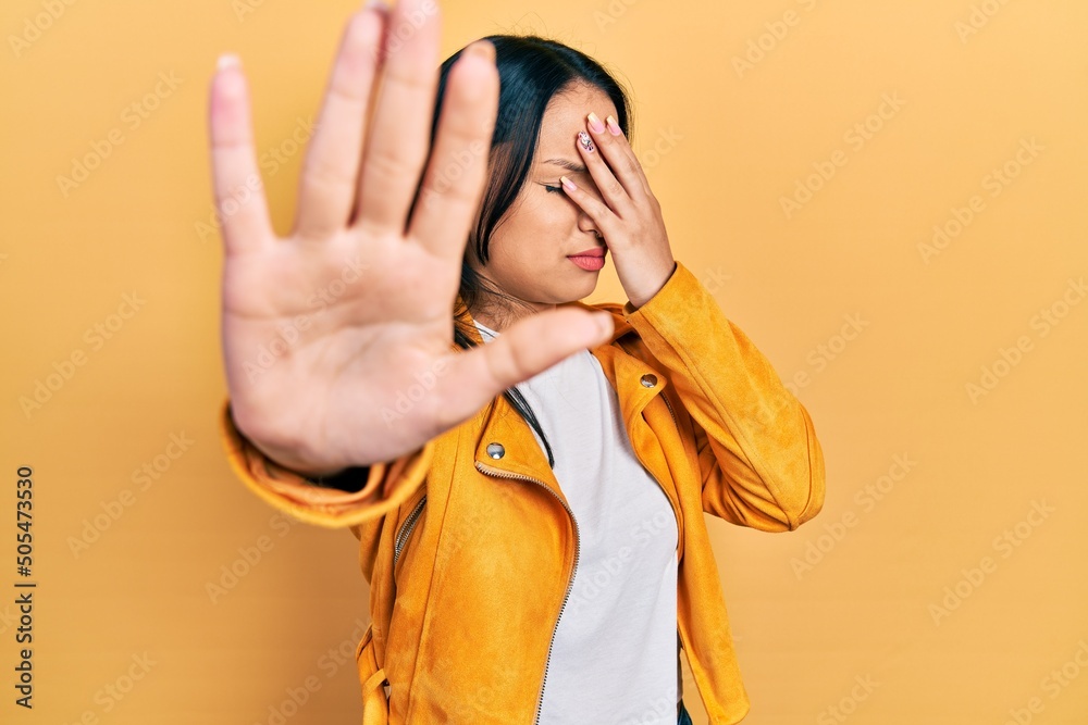 Beautiful hispanic woman with nose piercing wearing yellow leather ...