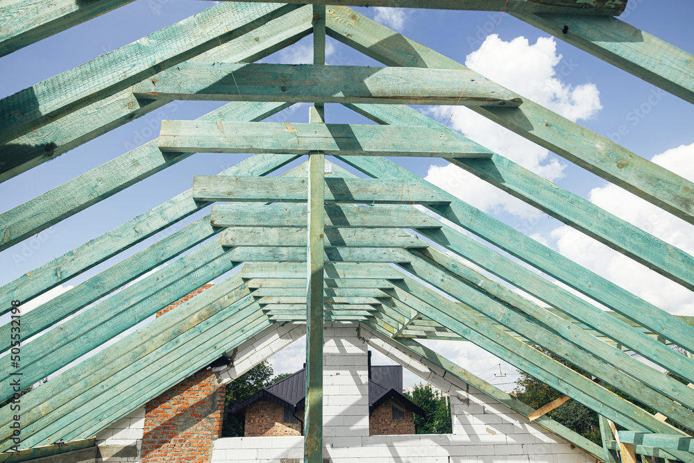 Wooden roof framing. Unfinished roof trusses and aerated concrete block ...