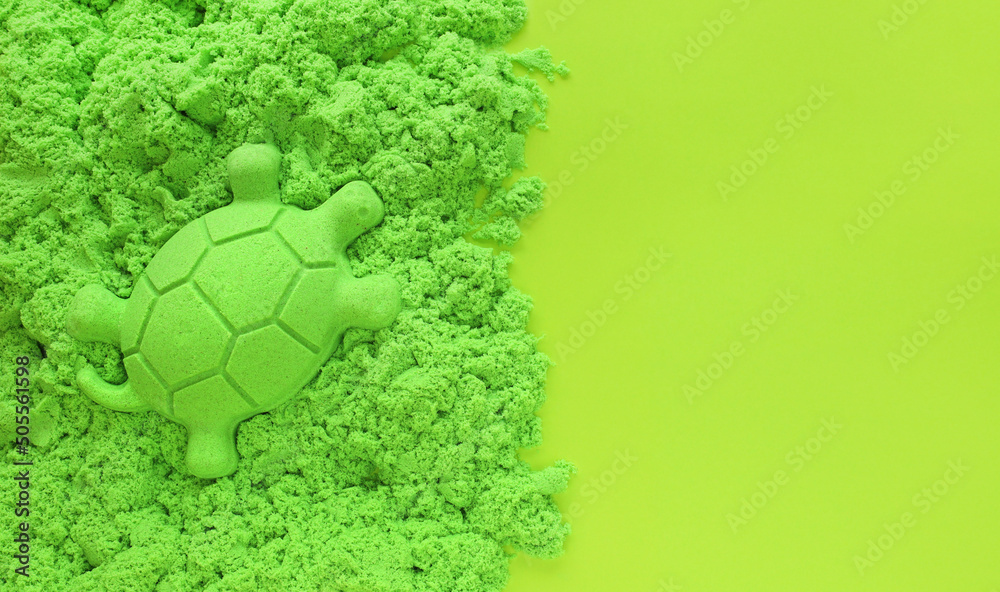 Green kinetic sand with turtle sand figure made from plastic mold on ...