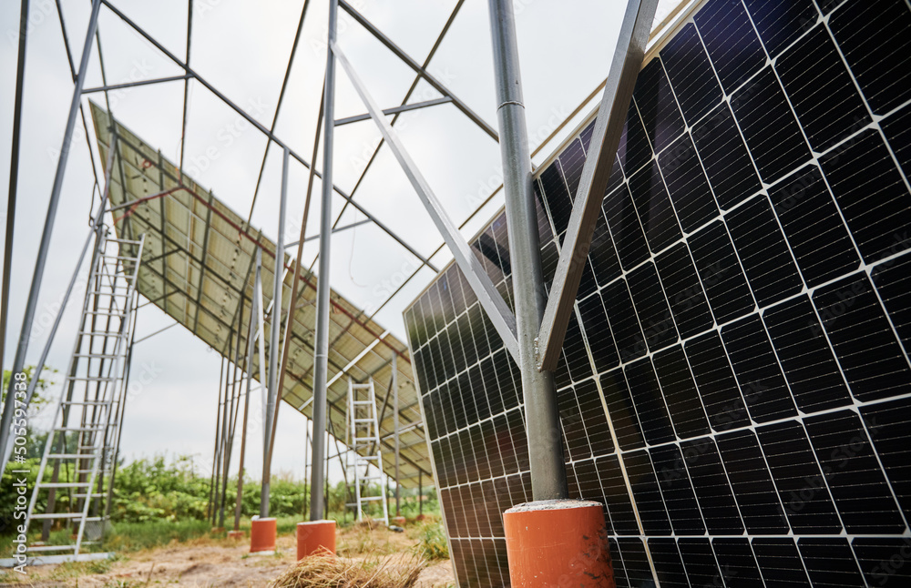 Close up of metal poles, rails, ladders and photovoltaic solar panels ...