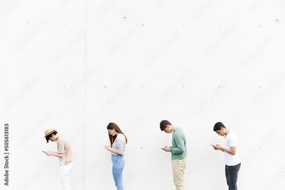 Foto de Queue of teenagers using their phones in bad posture. Lordosis ...