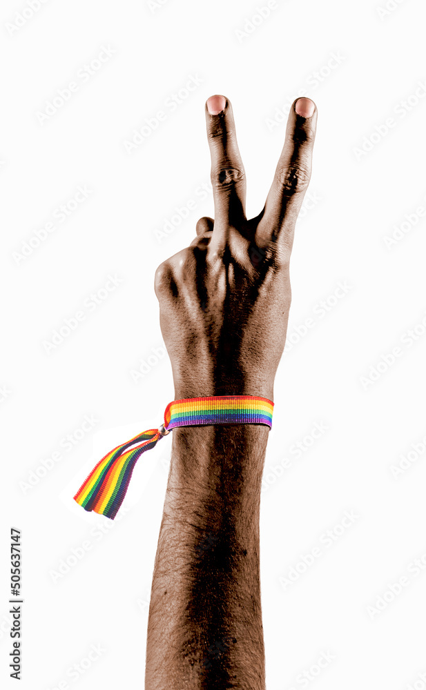 Foto de Black hand wearing a bracelet with the colors of the LGBT flag ...