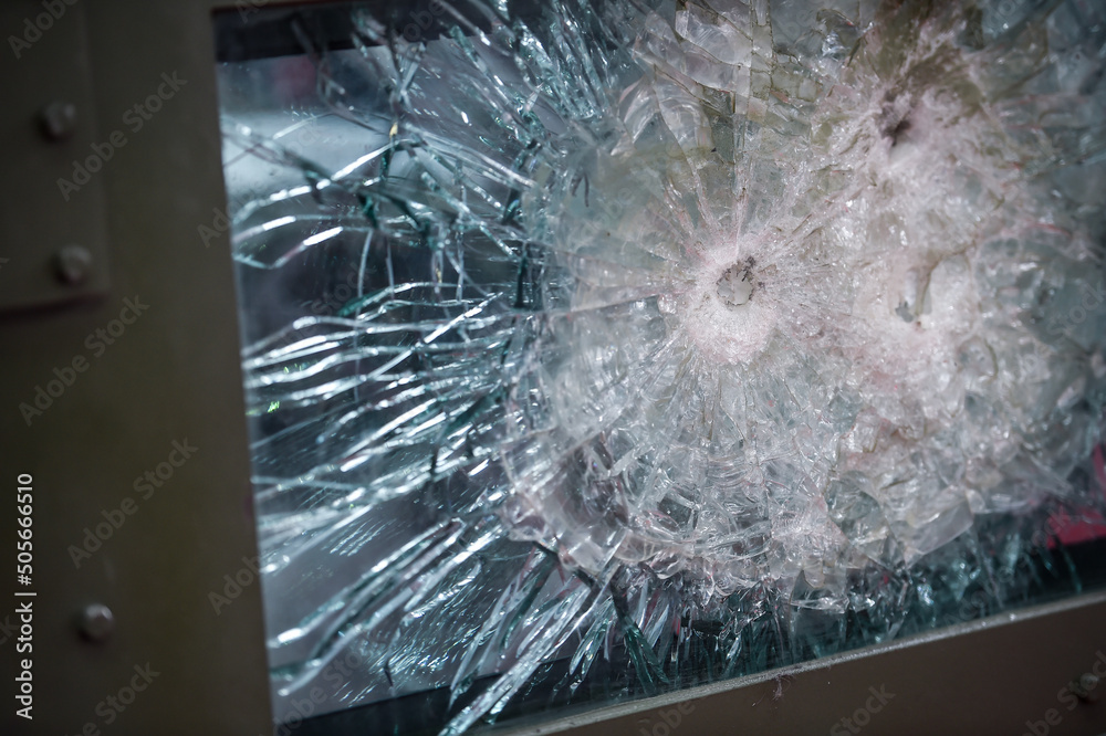 Detail with bullet gun shots through a armored window of a military ...