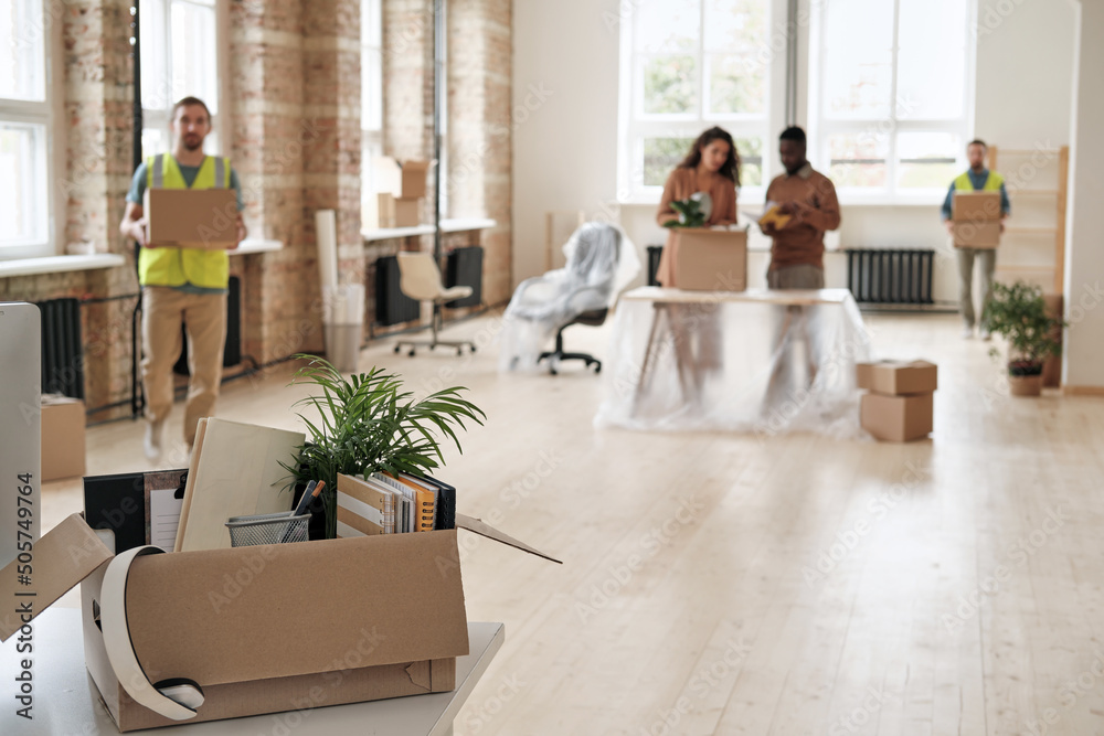 Cardboard box full of notepads and personal stuff placed on table ...
