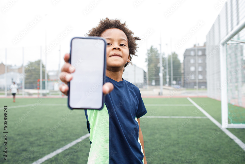 Kid using phone. Smiling and excited boy showing smartphone empty ...