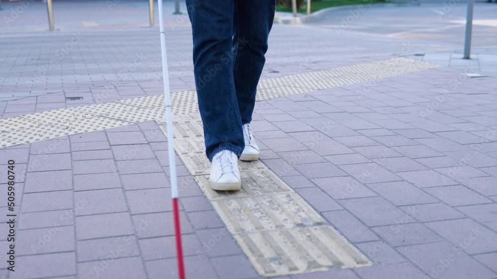 Legs of blind person searching special tactile tiles using cane. Blind ...