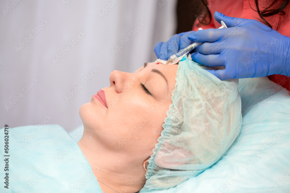 Injection facial rejuvenation. The cosmetologist injects cosmetic ...