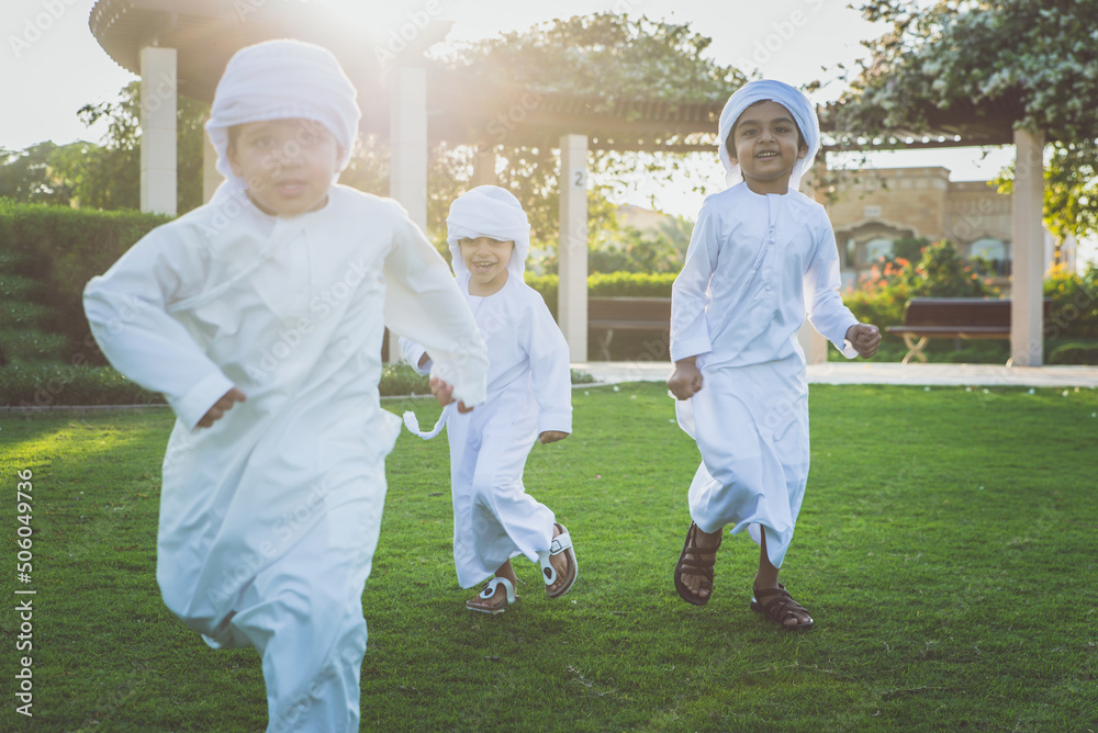 Children playing together in Dubai in the park. Group of kids wearing ...