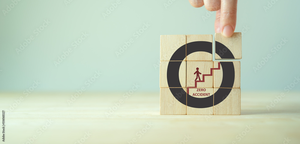 Zero accident and work safety concept. Placing wooden cube with icon of ...