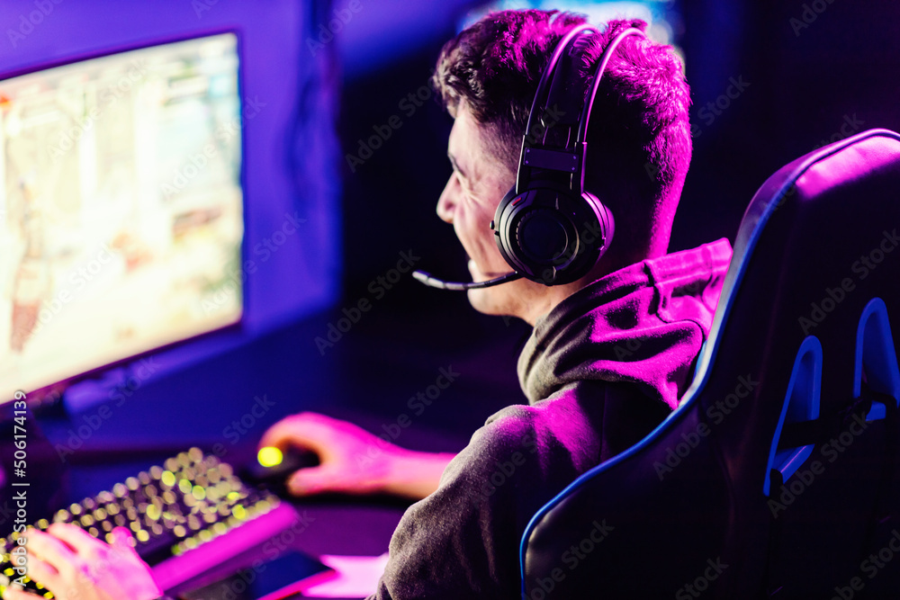 Rear view of professional gamer finishing mission on video game at ...