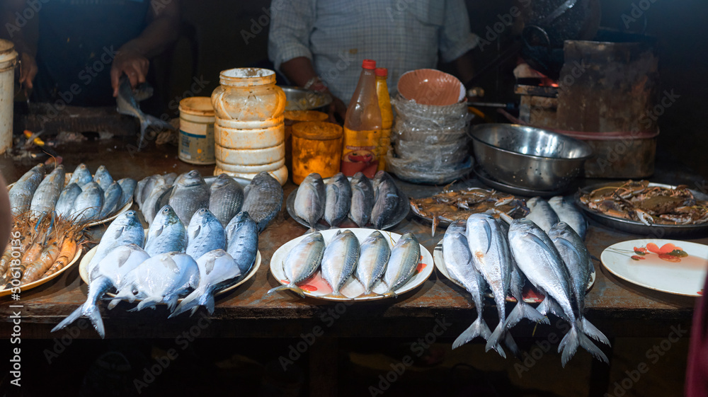 variety of fresh sea fishes on display at a fish fry stall (snack food ...
