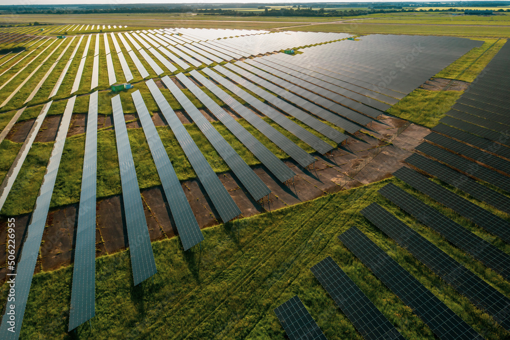 Large solar power plant on a picturesque green field. Solar panels in ...
