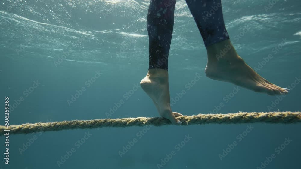 Vidéo Stock beautiful woman in flowing dress walk rope underwater dark ...