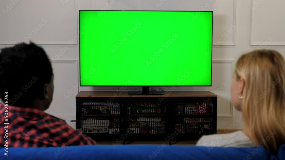 Green screen TV set multiethnic family couple looking at TV chroma key ...