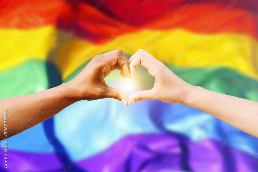 Two multiracial hands join together to form a shape heart with a LGBT ...