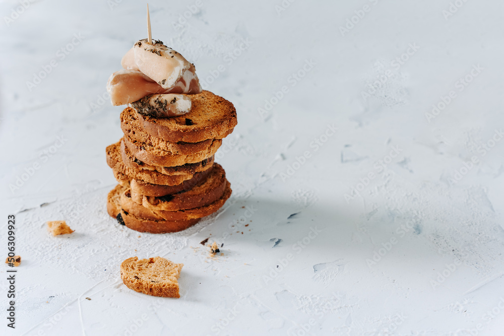 Food background. A tower of crispy toast with olives and ham and cream ...