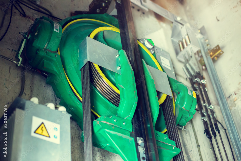 Selective focus to part of passenger lift. wheel rotating with sling ...