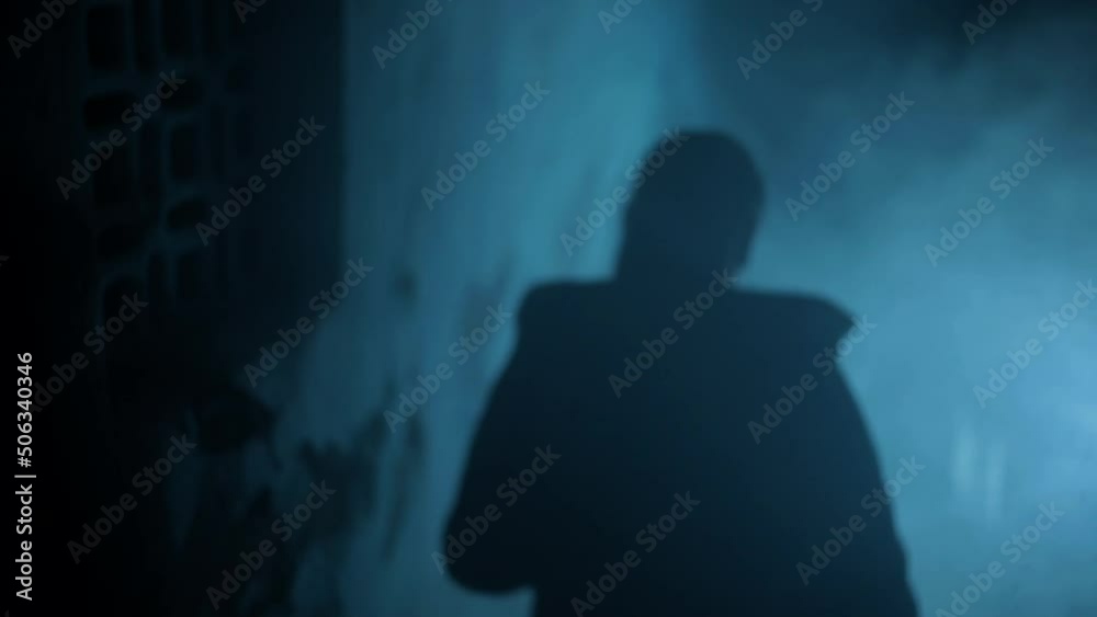 Professional female hitman in a suit with a gun in his hand, walking ...