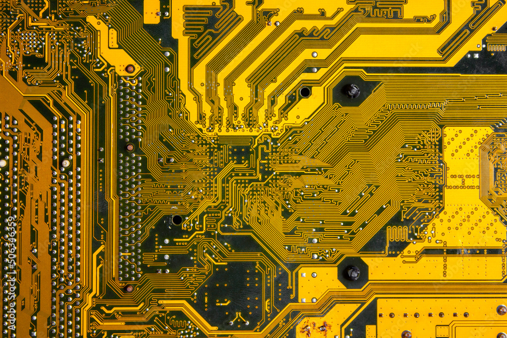 Close-up of a yellow circuit board. The reverse side of the motherboard ...