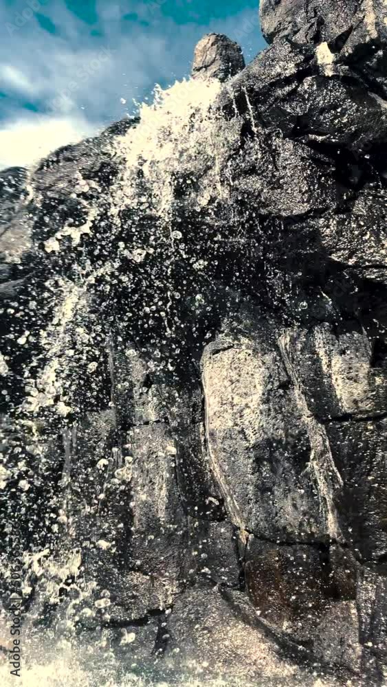 Waterfall and large rock boulders with crystal clear turquoise blue ...