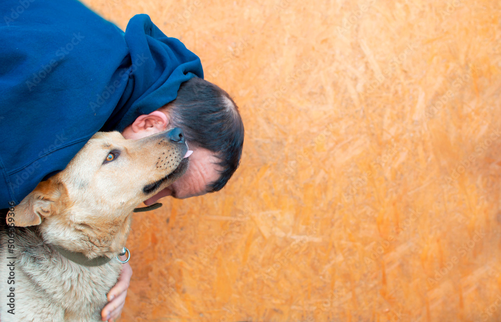guy and his dog. Portrait of a young balding man hugging his pet. The ...