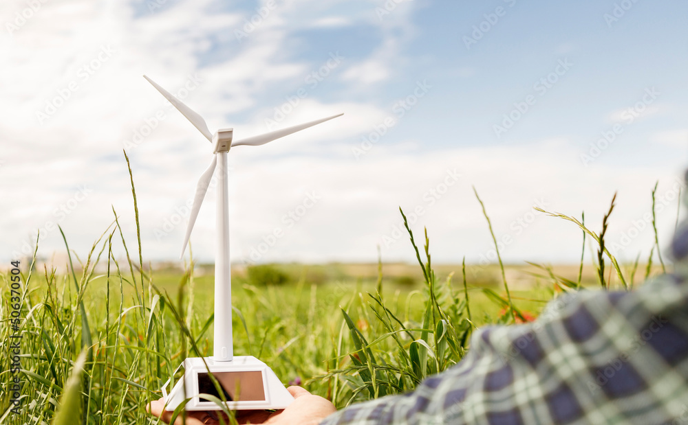 Hand of man holding wind turbine model in green field Stock Photo ...