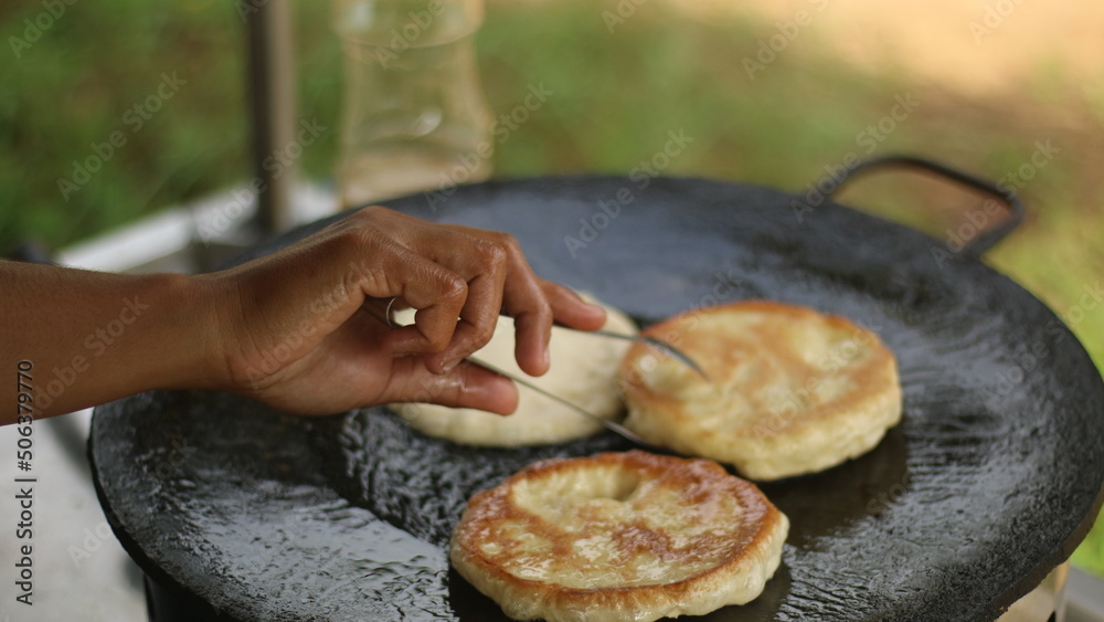 Street hawker preparing prata bread or roti canai for morning breakfast ...
