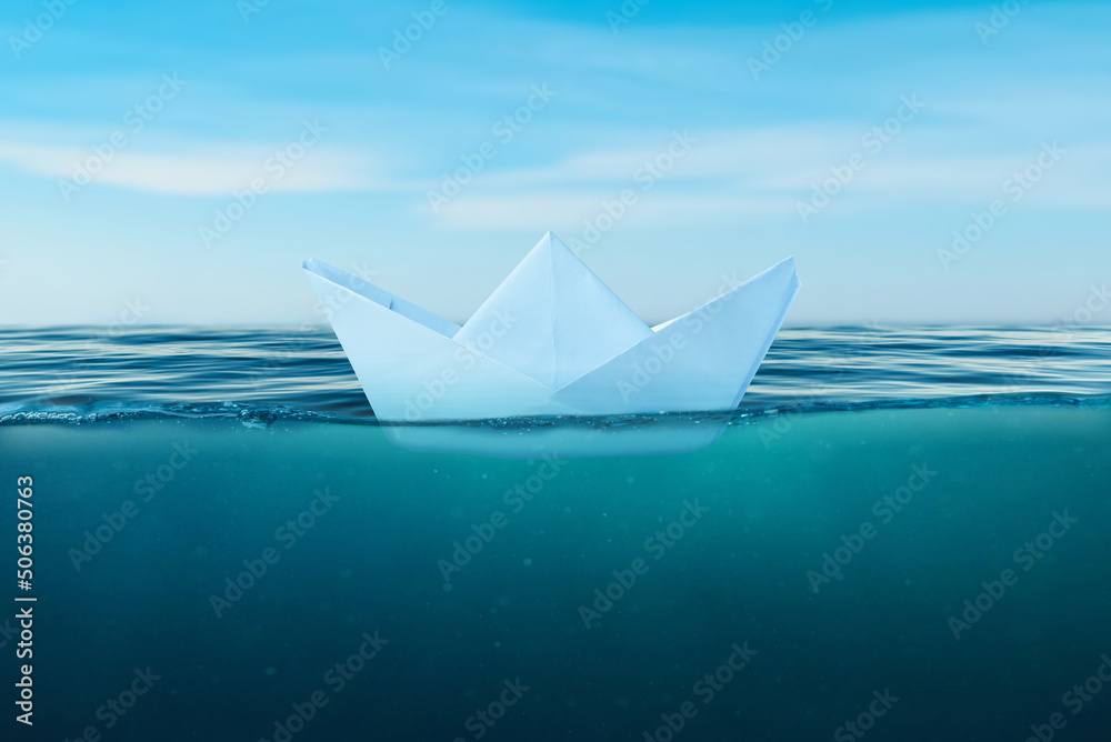 Paper boat on the sea surface. View under the sea. The concept of ...