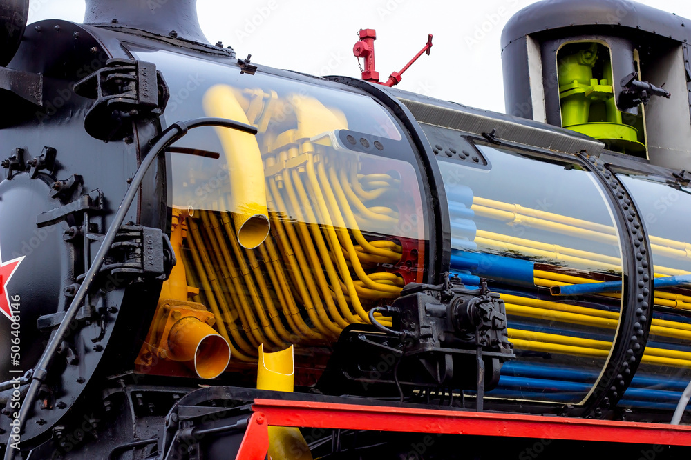 Old black and red retro steam locomotive at the railway station with a ...