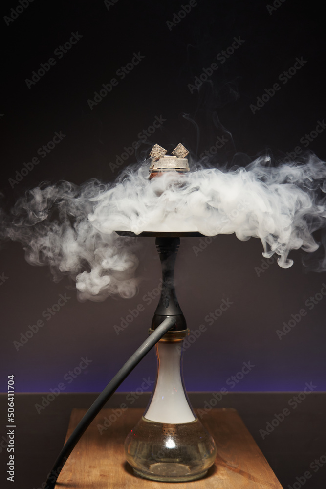 beautiful hookah with white smoke and transparent flask. a lot of white ...