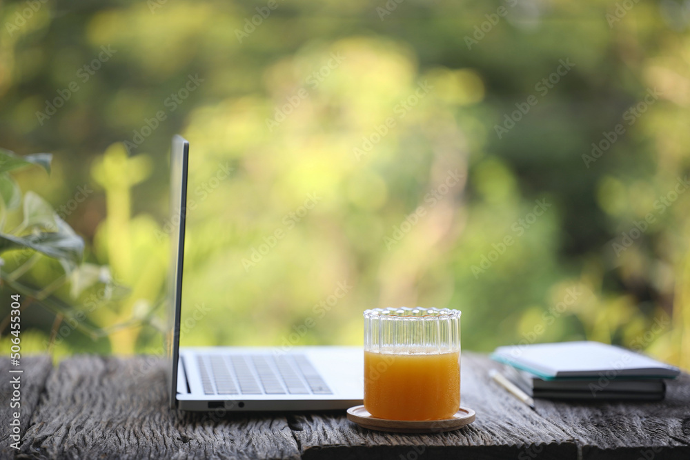 Laptop side view and mango juice in glass cup and notebooks Stock Photo ...
