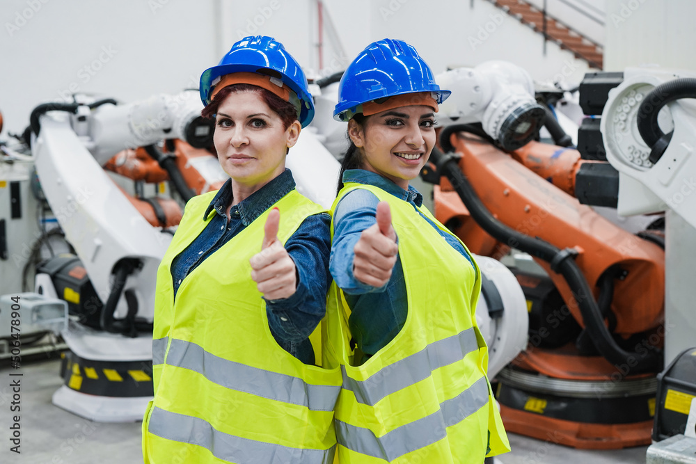 Women working inside rocotic factory - Female team with thumbs up Stock ...