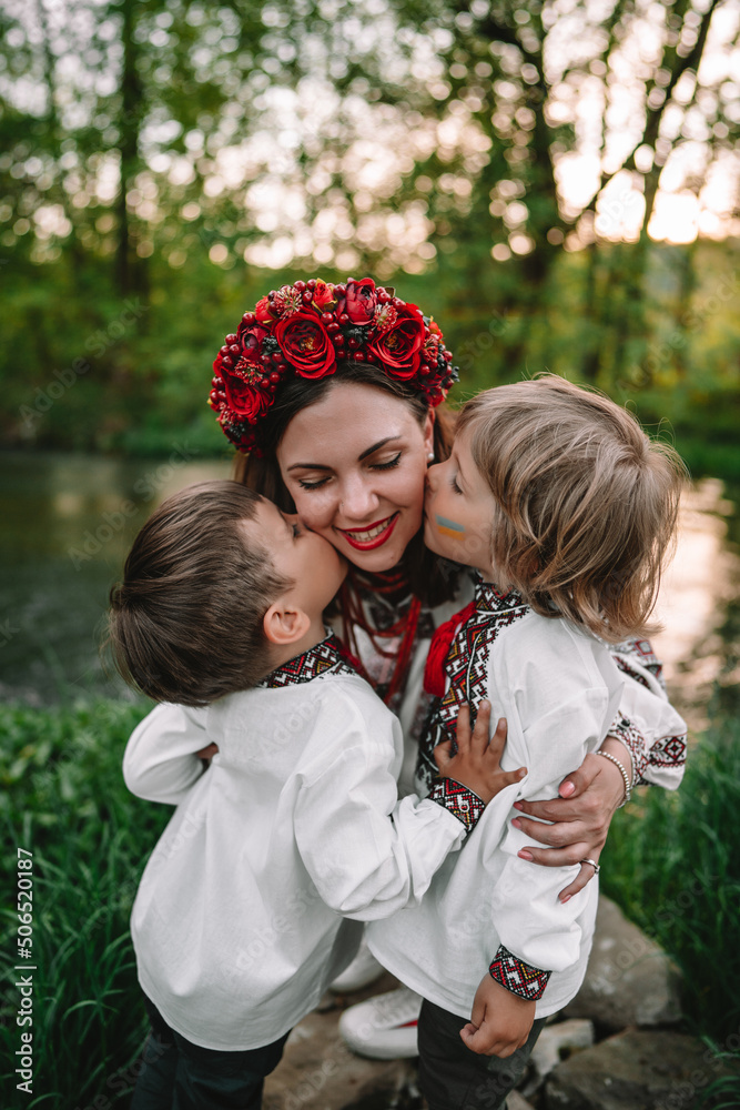 Little ukrainian boys kissing mother on cheeks. Happy family in ...