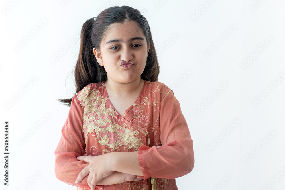 Portrait of Pakistani cute little girl showing funny face against white ...