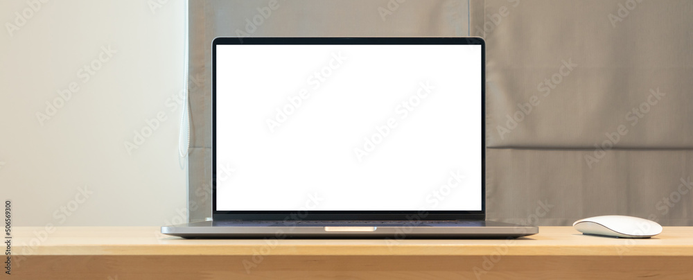 Blank screen laptop computer on wood table top in home office room ...