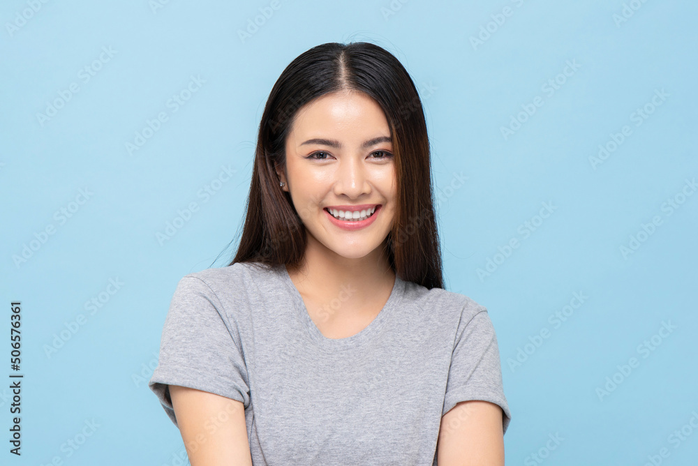 Portrait of pretty southeast Asian girl smiling in light blue color ...