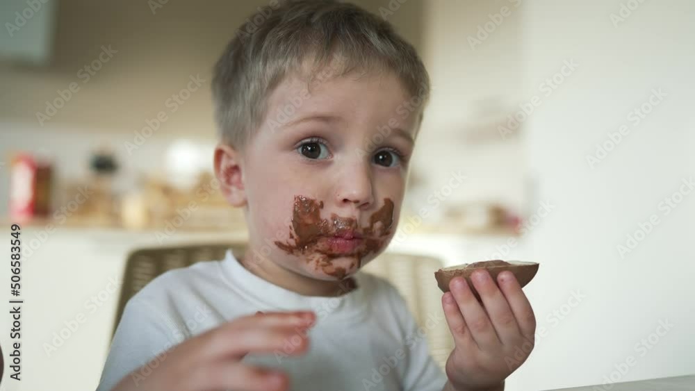 Child children eat sweet chocolate at table. Dirty face child mouth ...