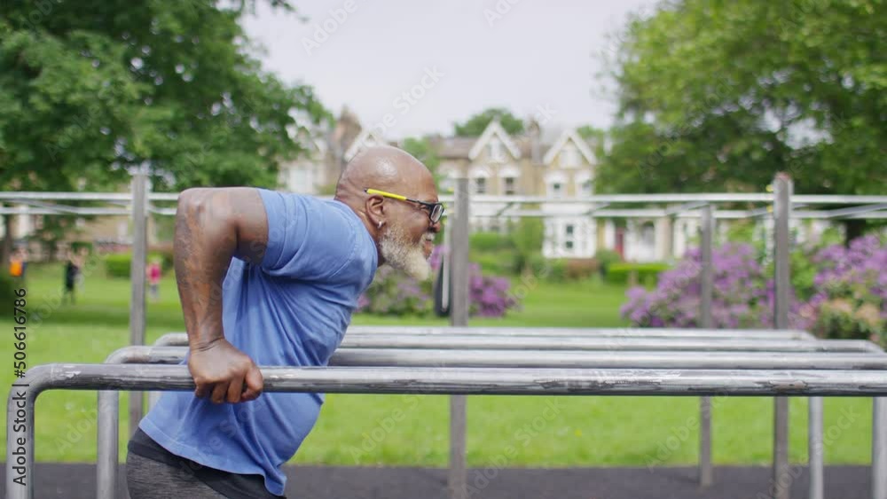 Muscular and healthy senior black male doing tricep dips on bars in an ...