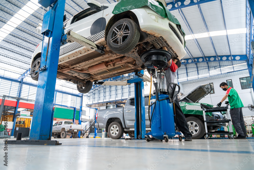 Auto mechanic working in Car repair station paved with epoxy floor and ...
