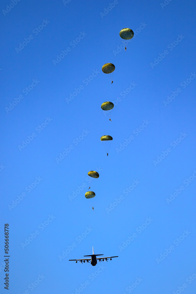 Military parachutist paratroopers parachute jumping out of a air force ...