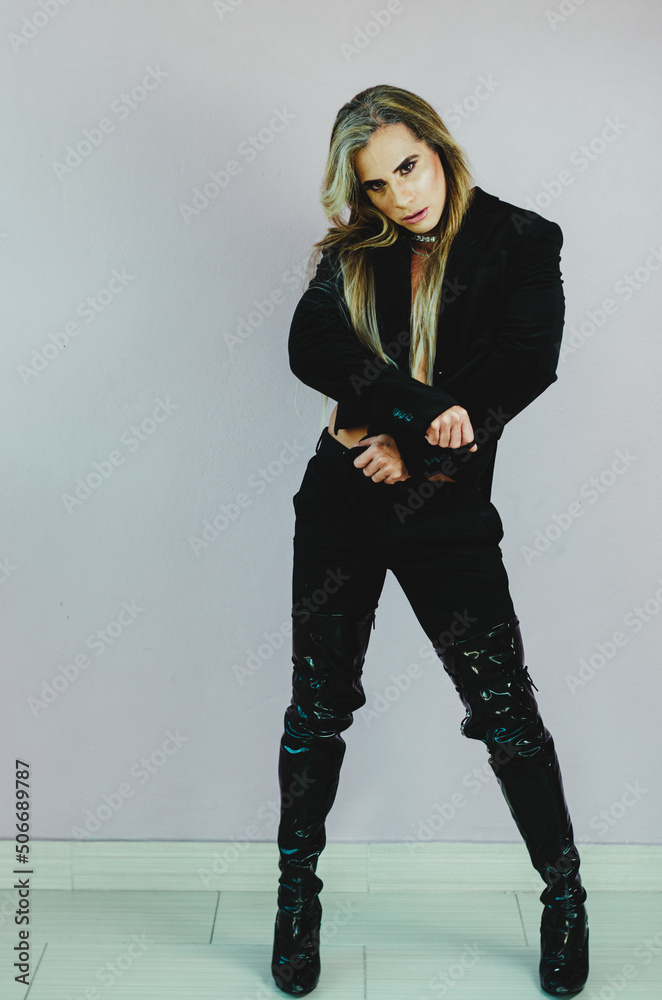 man dressed as a woman with long hair and black clothes and boots with ...